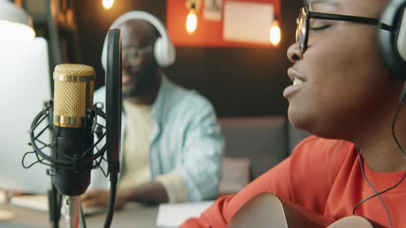 Portrait of African American Female Podcaster in Home Studio by AnnaStills