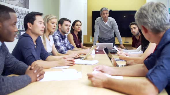 Male Boss Addressing Meeting Around Boardroom Table, Stock Footage
