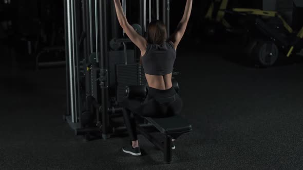 Female in the Gym Lifting Blocks on Rack Machine Back View Training on ...