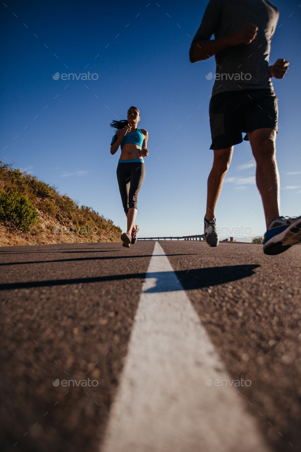 Woman running on road with man in front Stock Photo by jacoblund ...