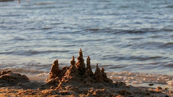 A Small Sandcastle On Beach With Waves On The, Stock Footage | VideoHive