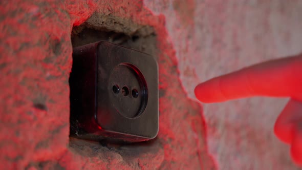 A Man Sticks His Finger Into the Socket Under Red Lighting Closeup ...