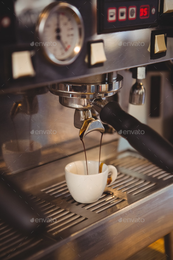 Machine making a cup of coffee in a cafe Stock Photo by Wavebreakmedia