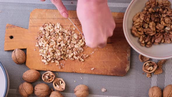 Chopping Walnuts Cores with Kitchen Knife on a Wood Cutting Board ...