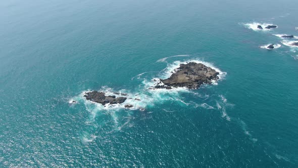 Aerial view of rocky islands washed by calm ocean waves on Java coast ...