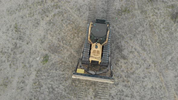 Top Aerial View on Tracked Bulldozer Rides on Sandy Road at ...