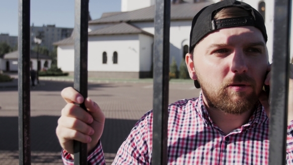 Man Talking On Phone At Gate With a Lattice, Stock Footage | VideoHive