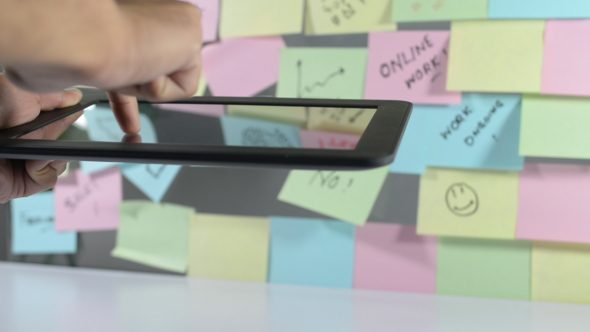 Man Using Tablet, Sticky Notes Wall in Background, Stock Footage ...