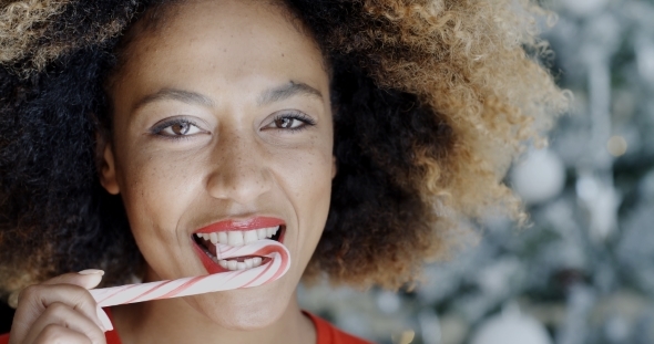 Young Woman Biting a Festive Candy Cane, Stock Footage | VideoHive