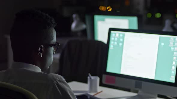 African Office Worker Sitting Alone in Office at Night, Stock Footage