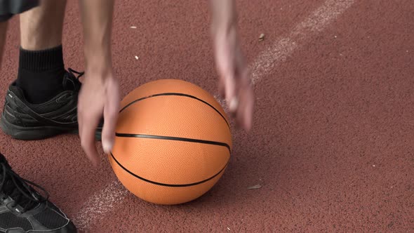 Caucasian Basketball Player Taking Ball From Ground Outdoors and ...