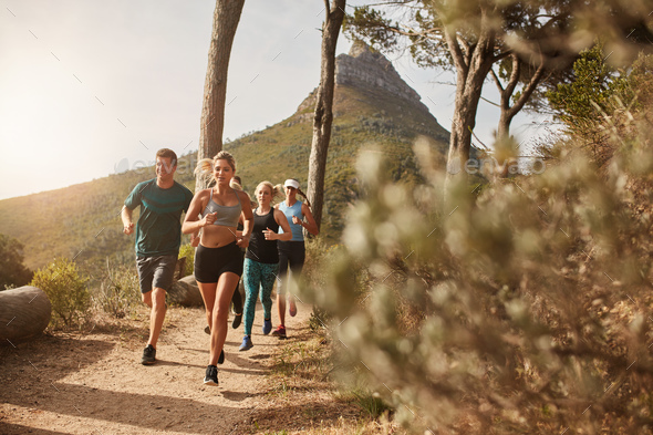 Group of fit people trail running on a mountain path Stock Photo by ...