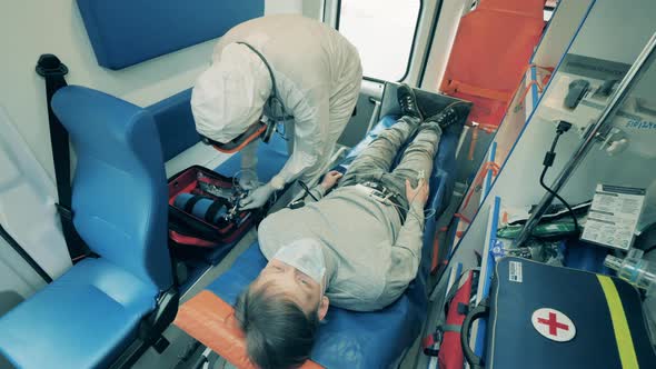 Medical Worker Connects Tubes To a Patient's Head in Ambulance Car ...