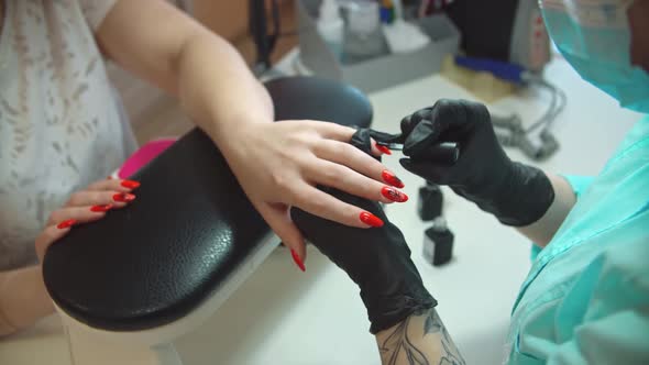 The manicurist finishes painting his nails. Manicure artist, Stock Footage