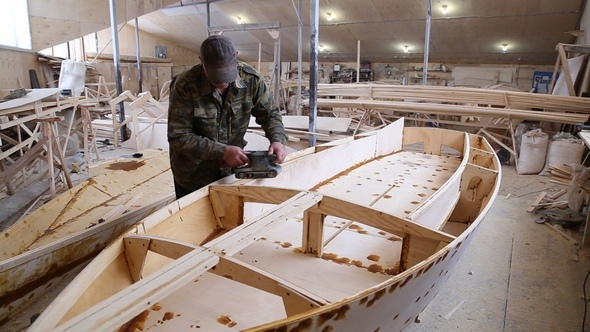 A Carpenter Polishes Details Wooden Boat at the Shipyard, Stock Footage