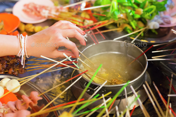 Woman eating traditional lok-lok street food from Asia Stock Photo by ...