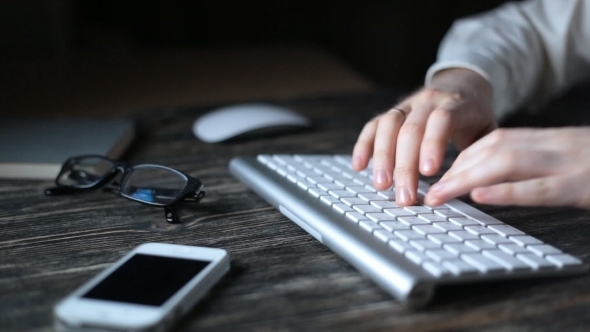 A Modern Workplace. Night Work. A Man Sits At a Computer And Types On ...