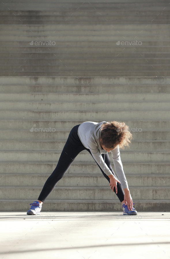 Young woman bending down stretching leg muscles Stock Photo by ...