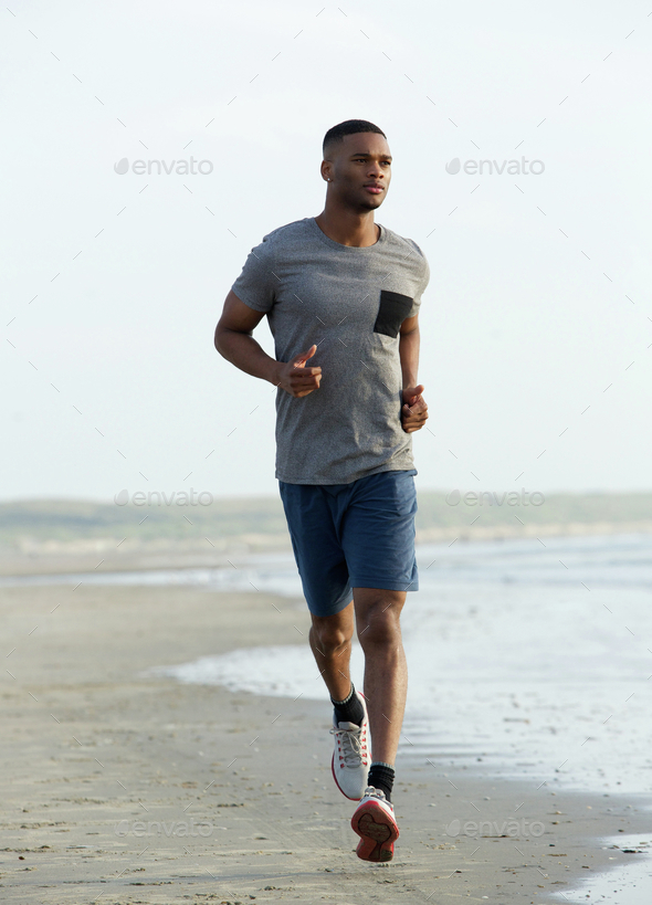 Young black man running on beach Stock Photo by mimagephotography ...