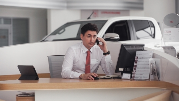 Handsome Car Salesman Talking On Cell Phone In Showroom, Stock Footage