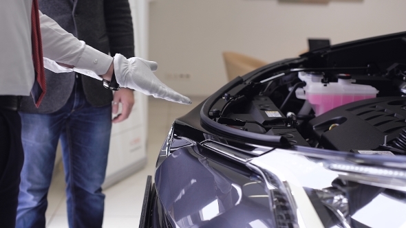 Salesman And Clients Or Customers In Car Dealership Presenting The ...