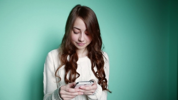 Beautiful Girl Looking In The Phone On a Turquoise Background, Stock ...
