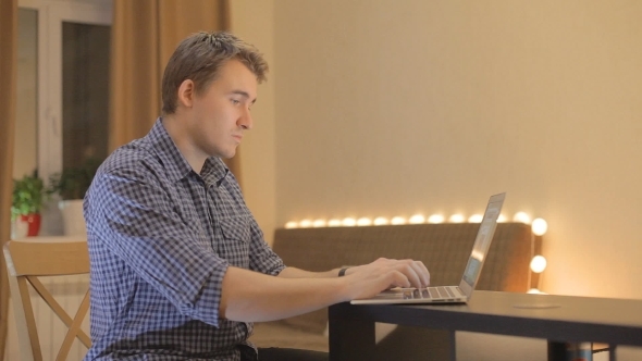 Young Man Working At a Laptop At Home, Stock Footage | VideoHive