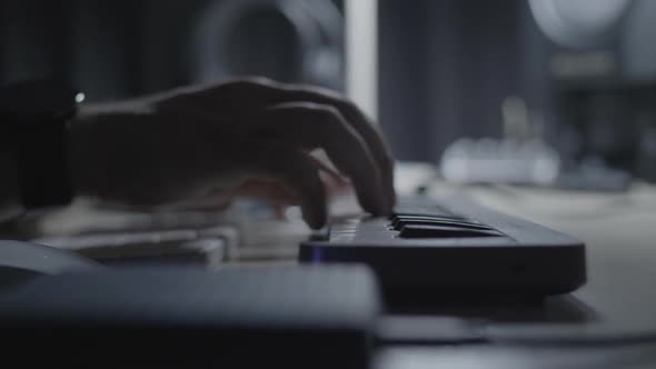 Close up on producer / musician hand playing a melody riff on a MIDI ...