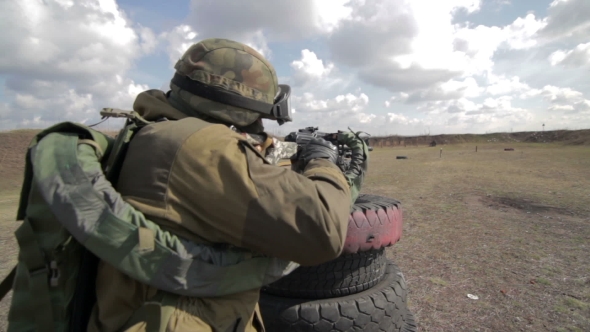 A Soldier With a Machine Gun On a Military Firing Range Shooting At a ...