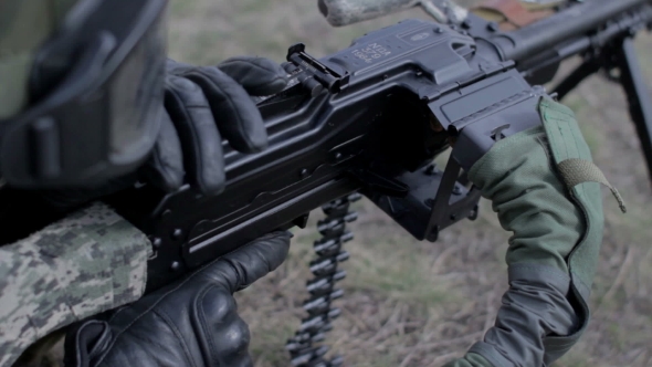 A Soldier With a Machine Gun On a Military Firing Range Shooting At a ...