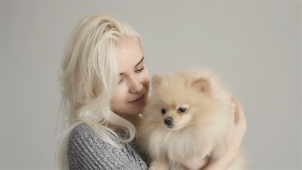 Beautiful Blonde Woman With Her Spitz Isolated On Grey, Stock Footage