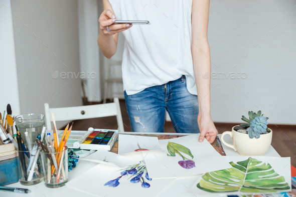 Woman artist taking photos of her drawings using smartphone Stock Photo ...