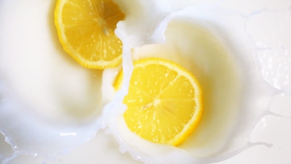 Two Lemon Pieces Drop Into Milk, Stock Footage | VideoHive