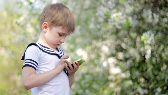 Young Little Boy Plays Games On Smartphone 1, Stock Footage | VideoHive