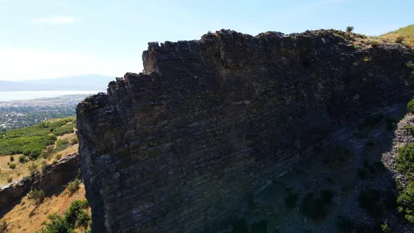 Looking at a shear cliff then ascend to reveal a view of a wide valley ...