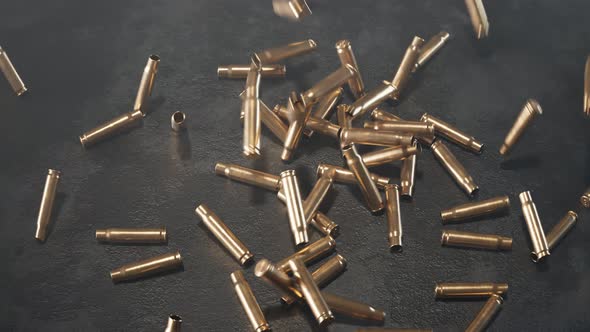 Empty shells falling down on the floor. Gun ammunition. Metal bullets ...