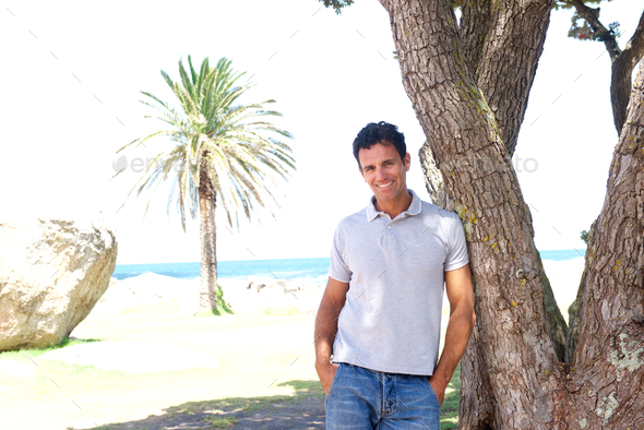 Smiling middle aged man standing outdoors Stock Photo by mimagephotography