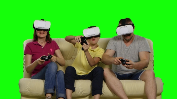 Family Playing In The Game Of Virtual Masks Sitting On The Sofa. Green ...
