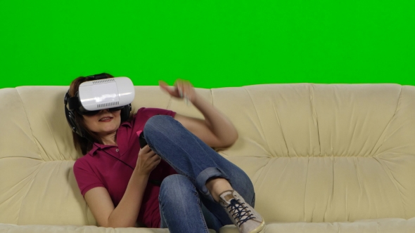 Woman In VR Glasses Playing Game While Sitting On Sofa At Home. Green ...