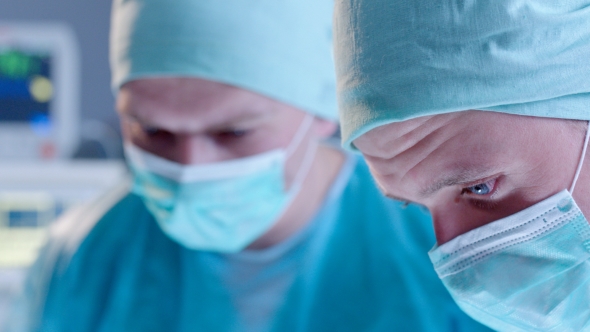 Surgeons Hunched Over The Operating Table, Stock Footage | VideoHive