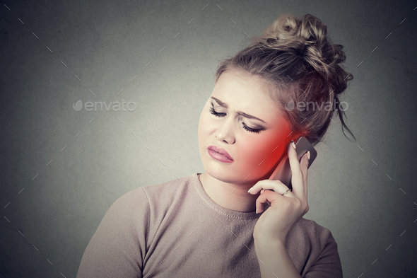 Concerned young woman talking on mobile phone having pain headache ...