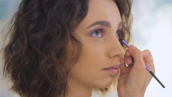 Professional Makeup Artist Applying Make Up On a Beautiful Young Face ...