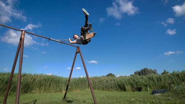 A Young Woman Is Swinging On a Swing At a Green Field., Stock Footage