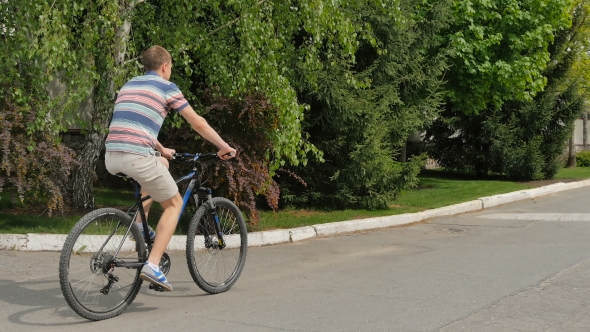 Man Rides a Bicycle Down The Street., Stock Footage | VideoHive