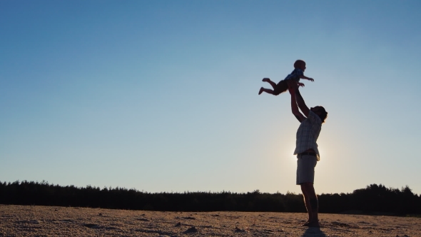 Father Playing With His Son - Throws It High Into The Sky. In The Rays ...