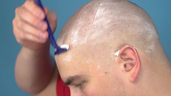 The Bald Young Man Insolently Shaves His Head Closeup. A Man Cuts His ...