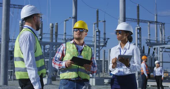 Three Electrical Workers Reviewing Documents on a Tablet, Stock Footage