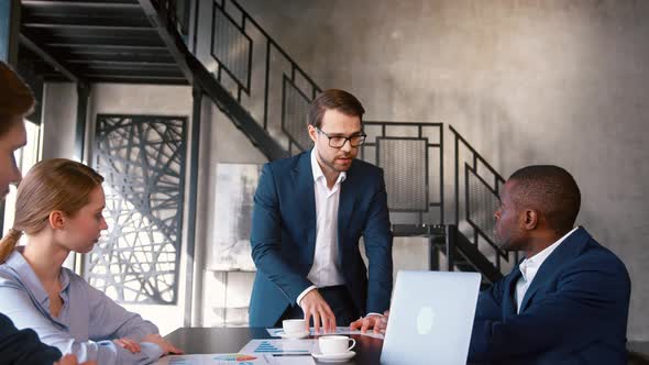 Young man team leader explaining company development strategy to young ...