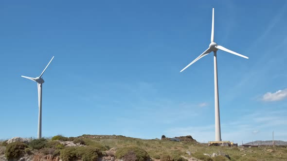 Diagonal Shot of Two Wind Turbines and Road In-between in Hill ...