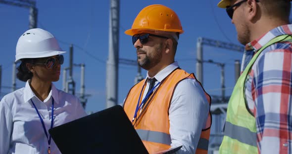 Three Electrical Workers Reviewing Documents Outside, Stock Footage